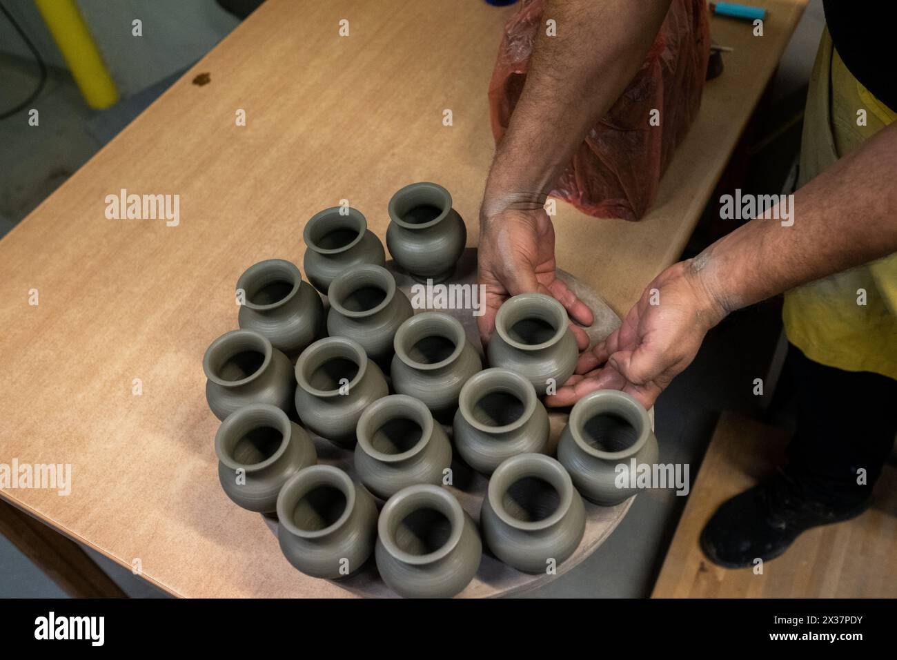 A potter making ceramic pottery inspired by ancient Greek amphorae in ...