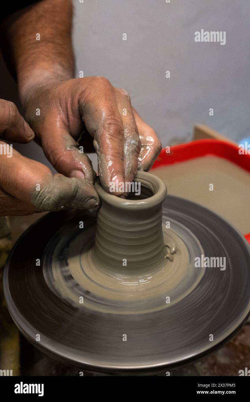 A potter making ceramic pottery inspired by ancient Greek amphorae in ...
