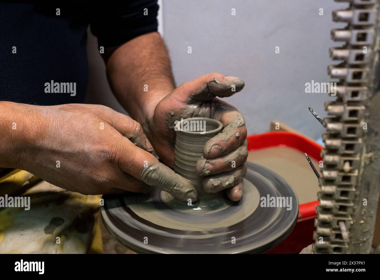 A potter making ceramic pottery inspired by ancient Greek amphorae in ...
