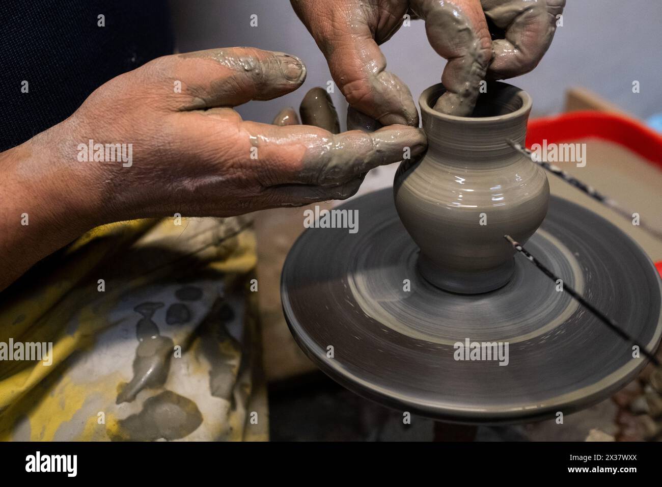 A potter making ceramic pottery inspired by ancient Greek amphorae in ...