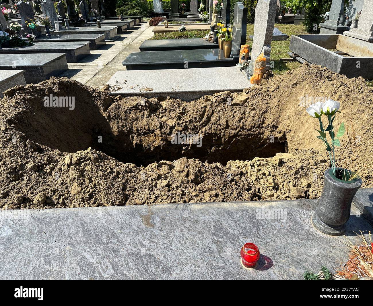 Newly dug out grave site in the public cemtery Stock Photo - Alamy