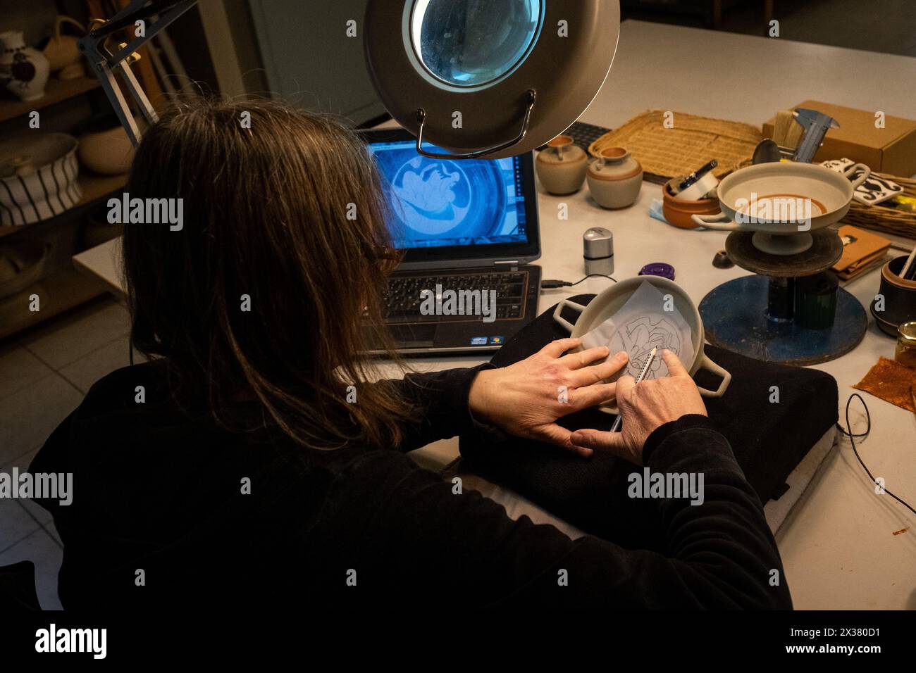 A woman carefully prepares to paint a vase inspired by ancient Greek ...