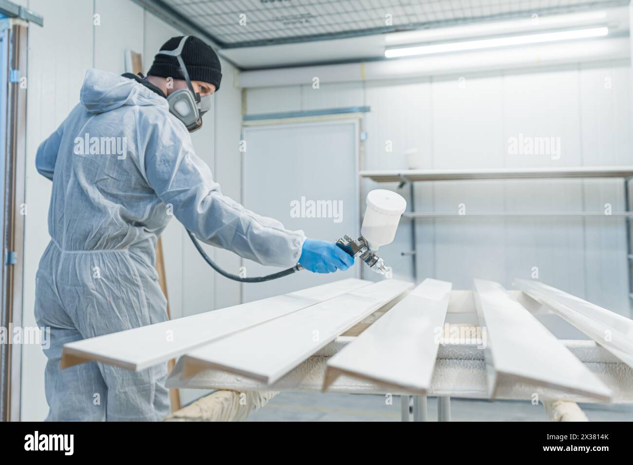 master painter in a factory, industrial painting wood with spray gun ...