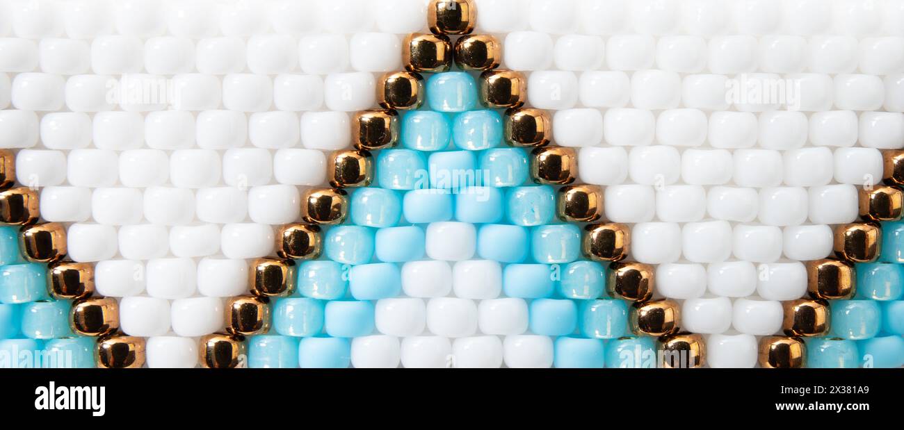 Macro shot of boho style beading backdrop. White, blue and bronze color ...