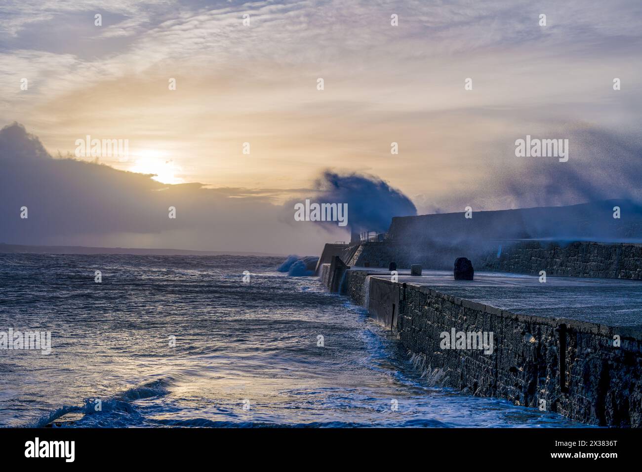 Waves crash over the pier and obscure the lighthouse Stock Photo - Alamy
