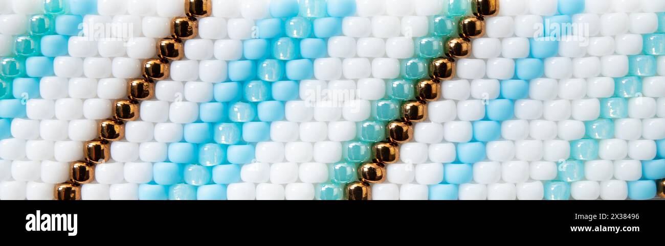 Macro shot of boho style beading backdrop. White, blue and bronze color ...