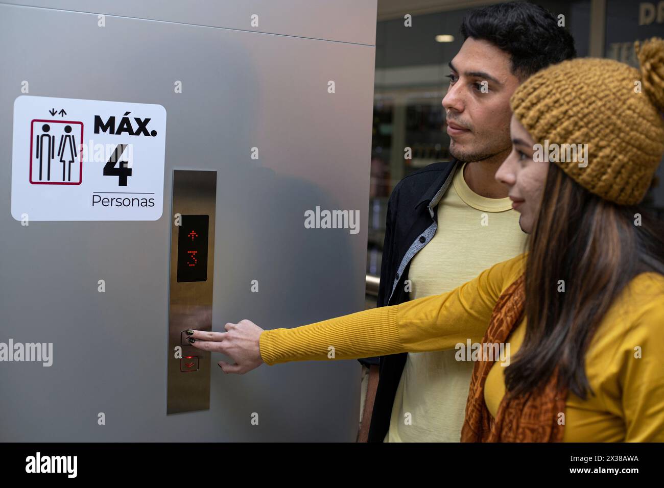 Two young Latin American brothers at the mall wait for the elevator ...