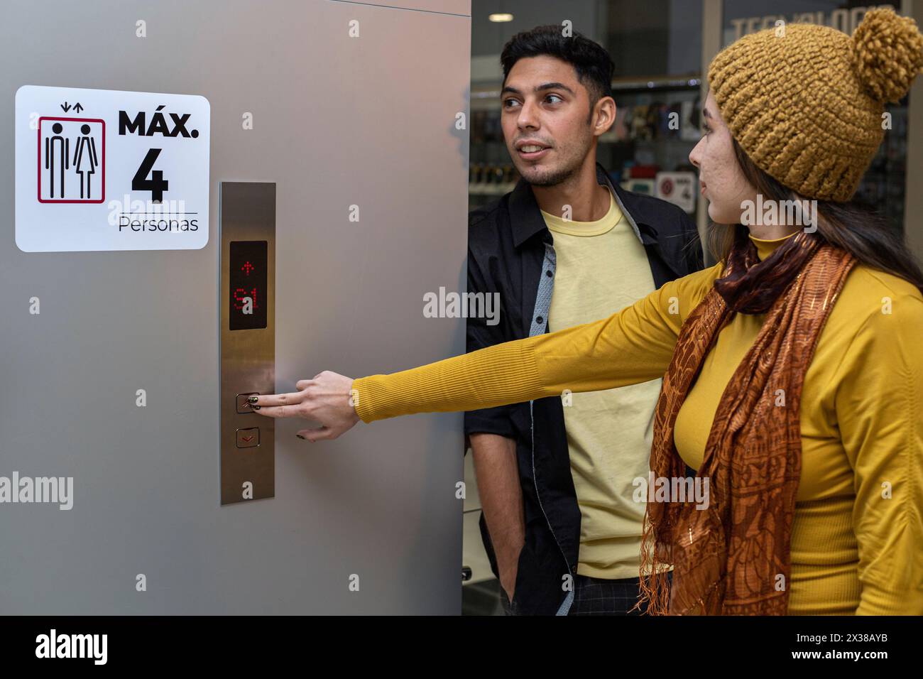 Two young Latin American brothers at the mall wait for the elevator ...