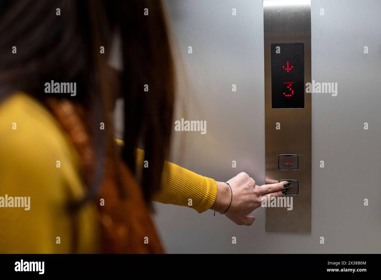 Woman presses elevator call button hi-res stock photography and images ...