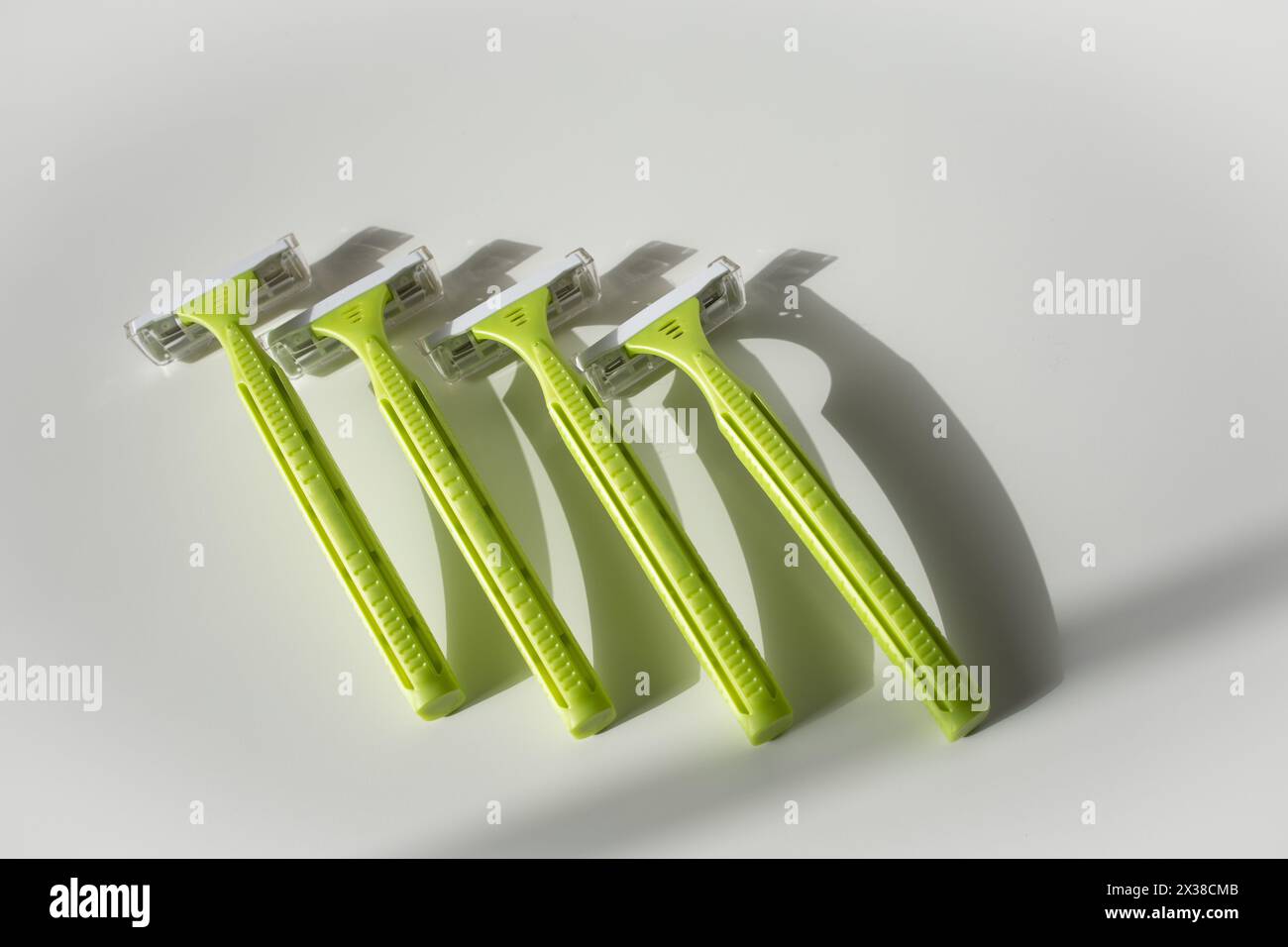 Green disposable shaving razors on white background Stock Photo - Alamy