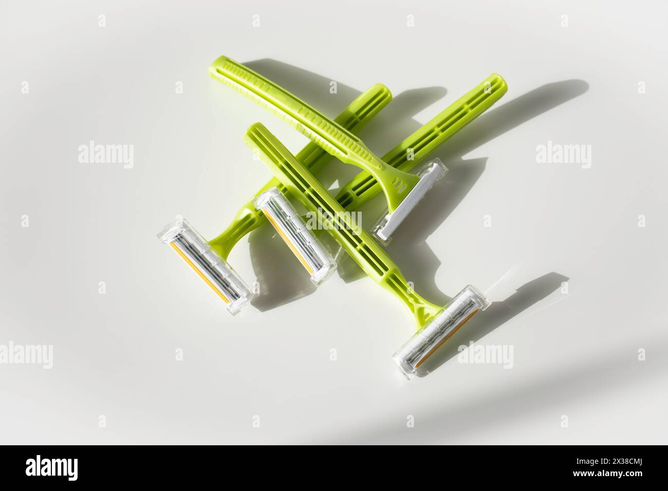 Green disposable shaving razors on white background Stock Photo - Alamy