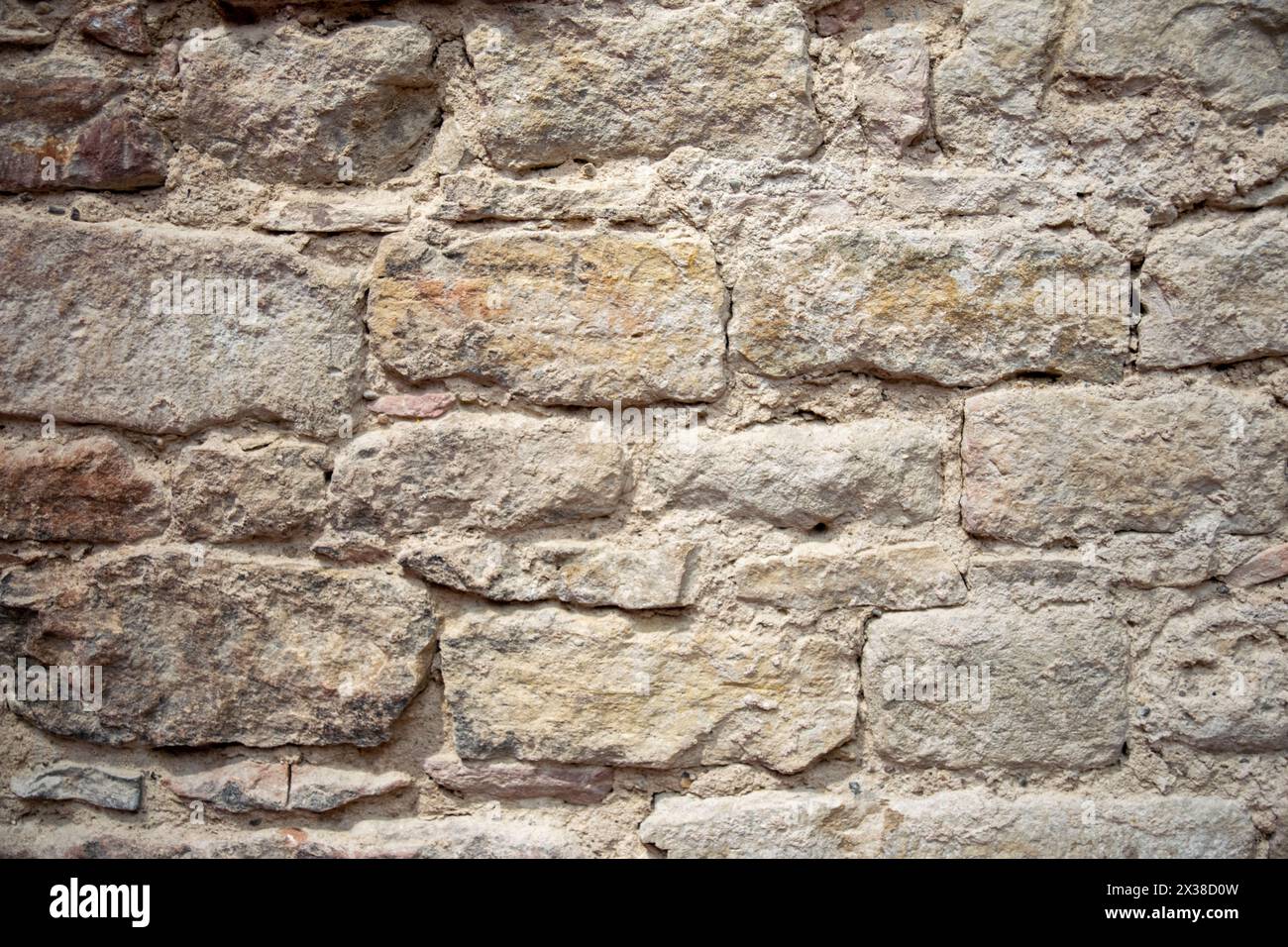 Gray structural stone wall of the ancient building consists of old dark ...