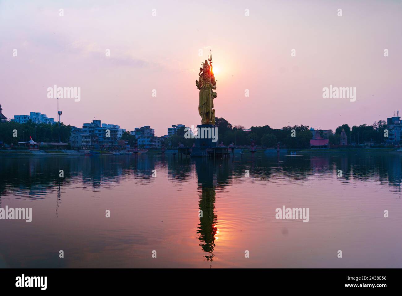 The Statue of Hindu god Lord Shiva in Sursagar Lake is seen at sunset ...