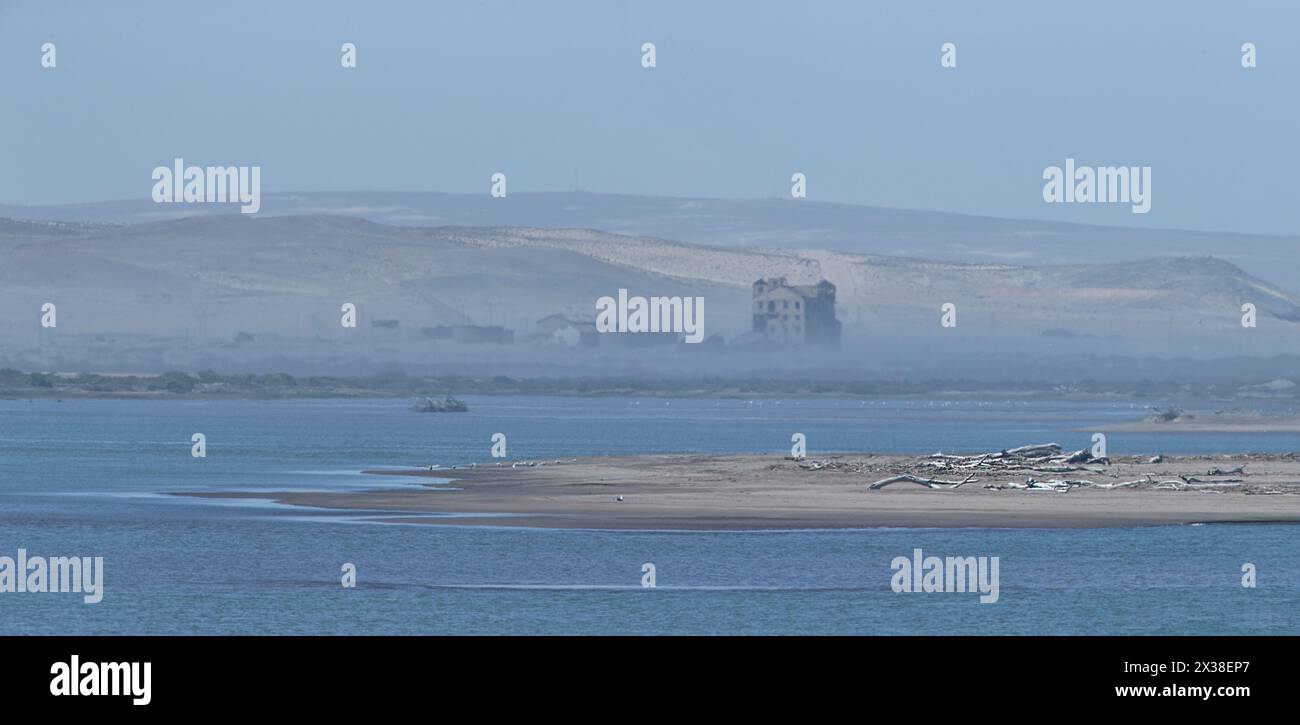 The mist clearing to show an exposed sand bar with driftwood and the ...
