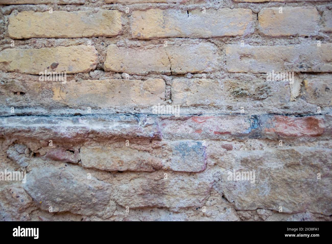 Gray structural stone wall of the ancient building consists of old dark ...