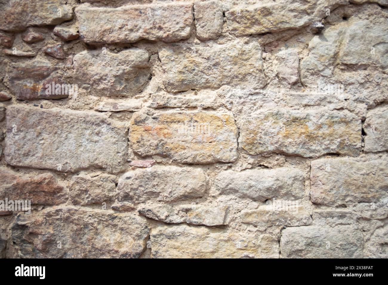 Gray structural stone wall of the ancient building consists of old dark ...
