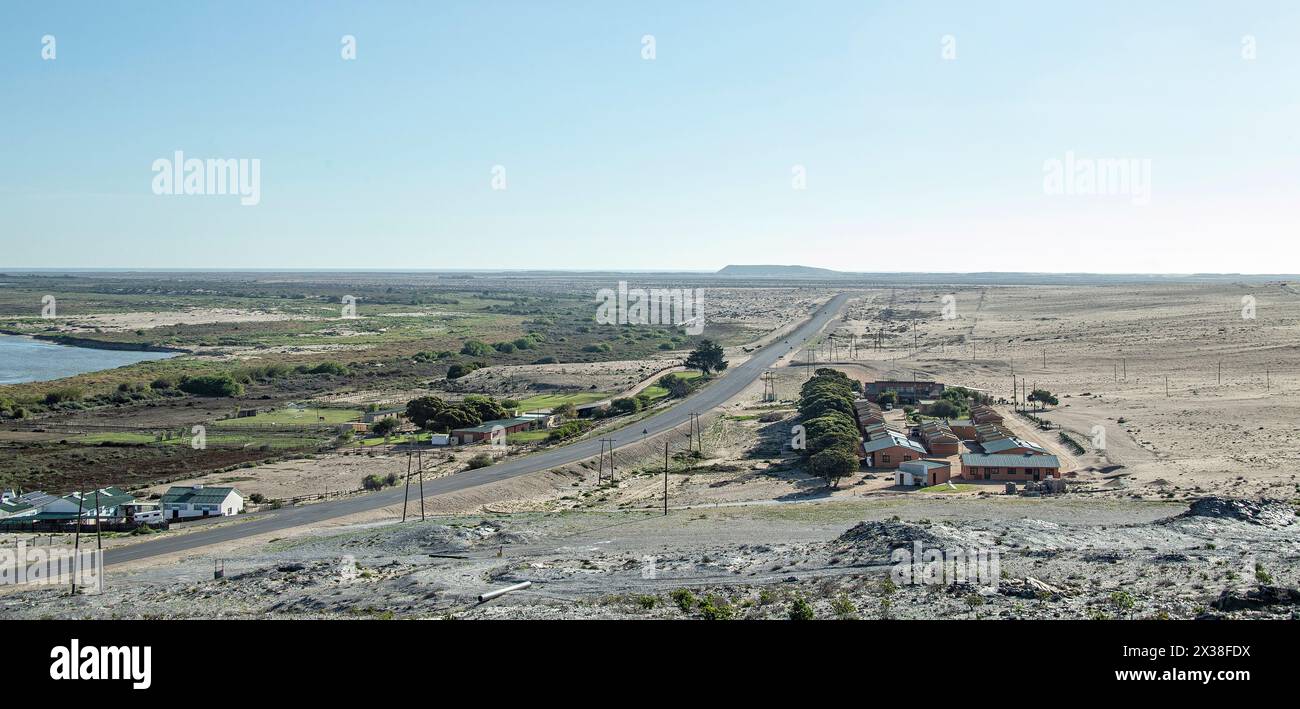 The road into Oranjemund crossing the coastal plain and leading to the spoil heap from a diamond ...