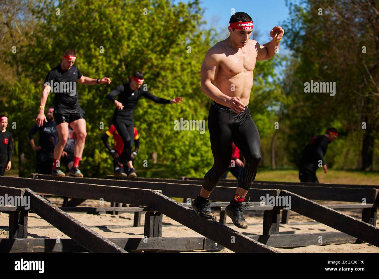 Muscular man walking on a balance beam at the Spartan Race competition ...