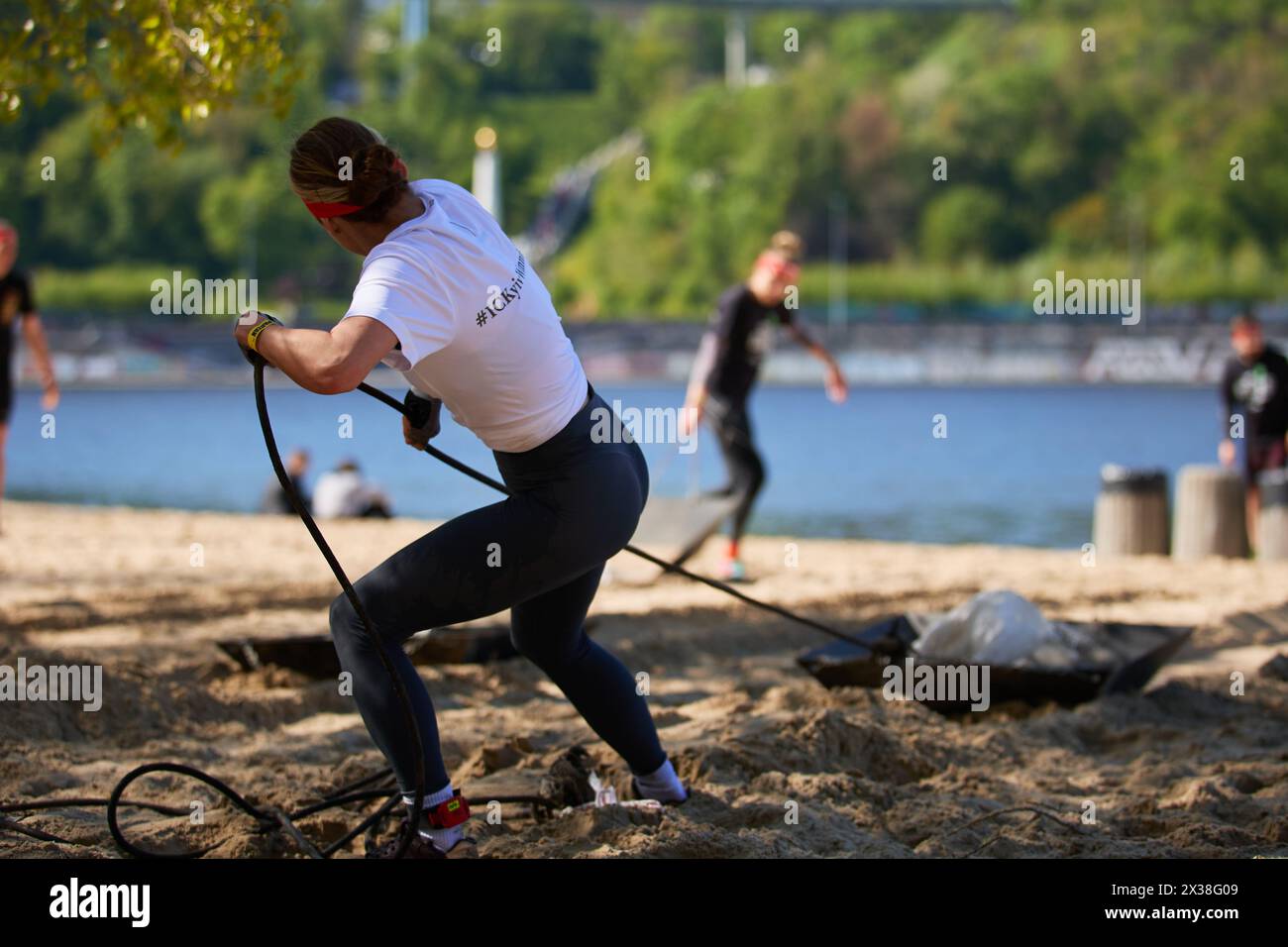 Strong young woman pulling the plate drag at the Spartan Race ...