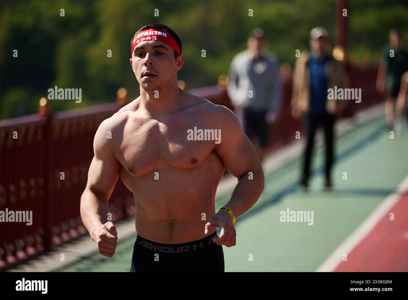Muscular young man runs the marathon distance during the Spartan Race ...