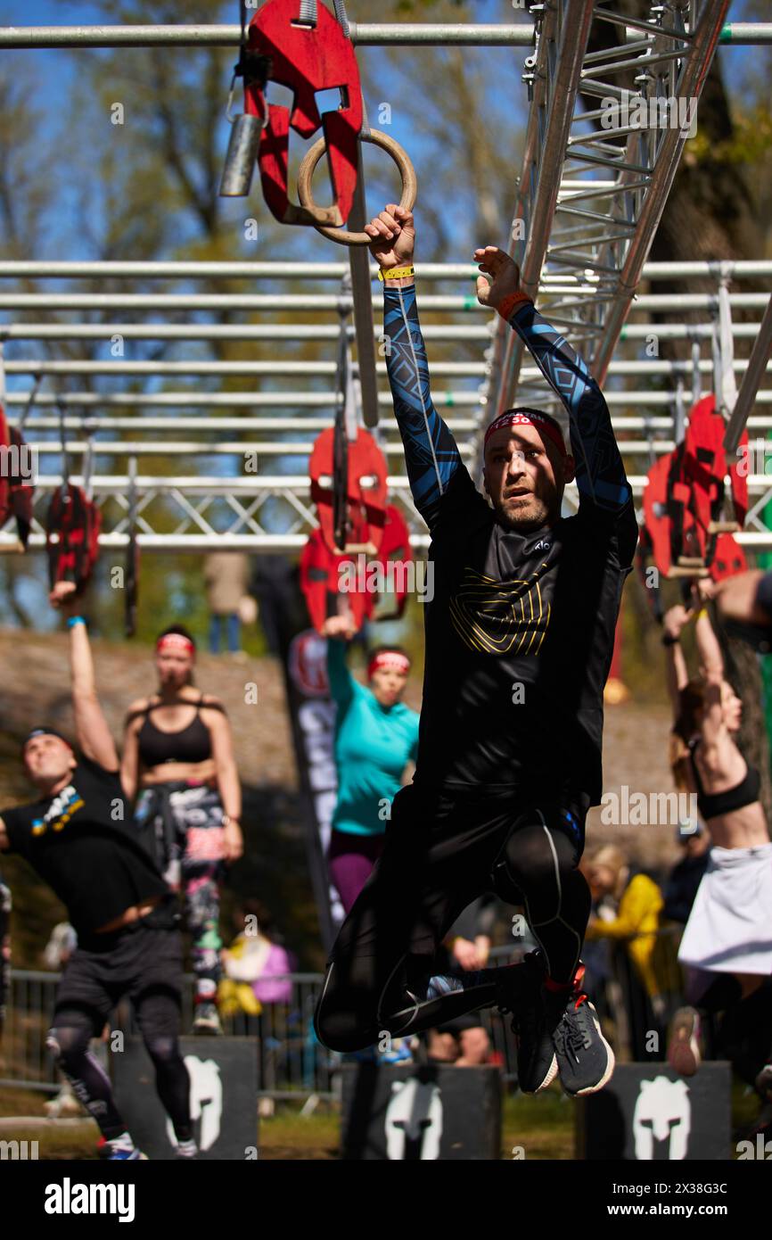 Ukrainian man swings on a ring swing at the Spartan Race competition in ...