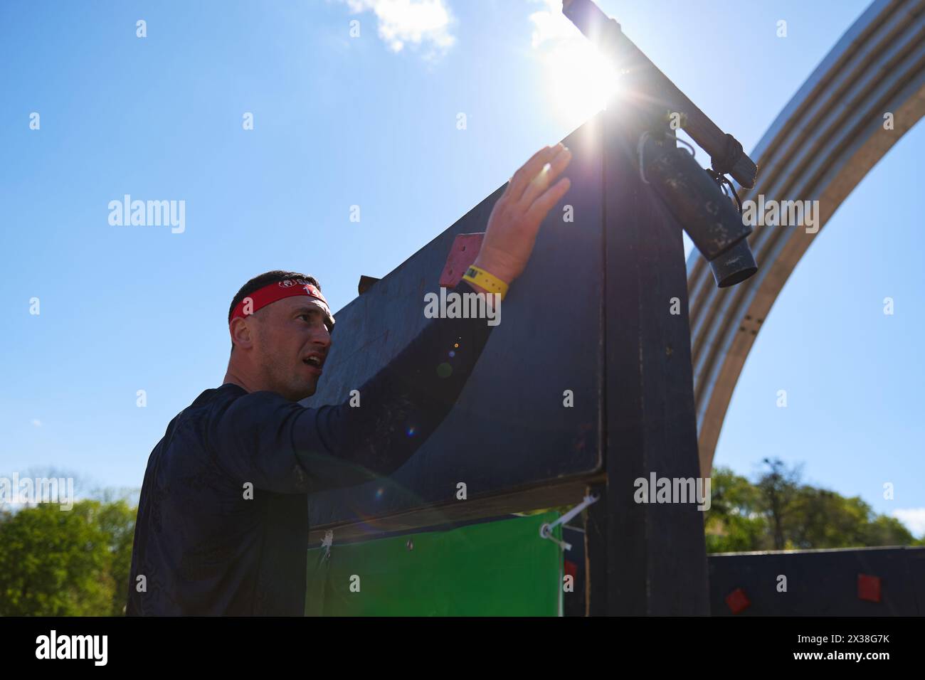 Athlete rings the bell at the finish line of an obstacle at the Spartan ...