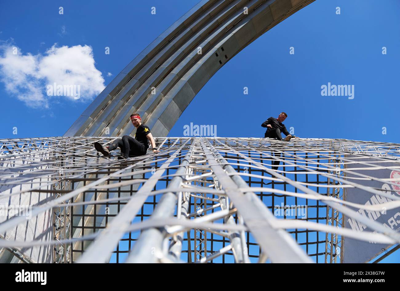 Athletes climbing the large pyramid obstacle at the Spartan Race ...