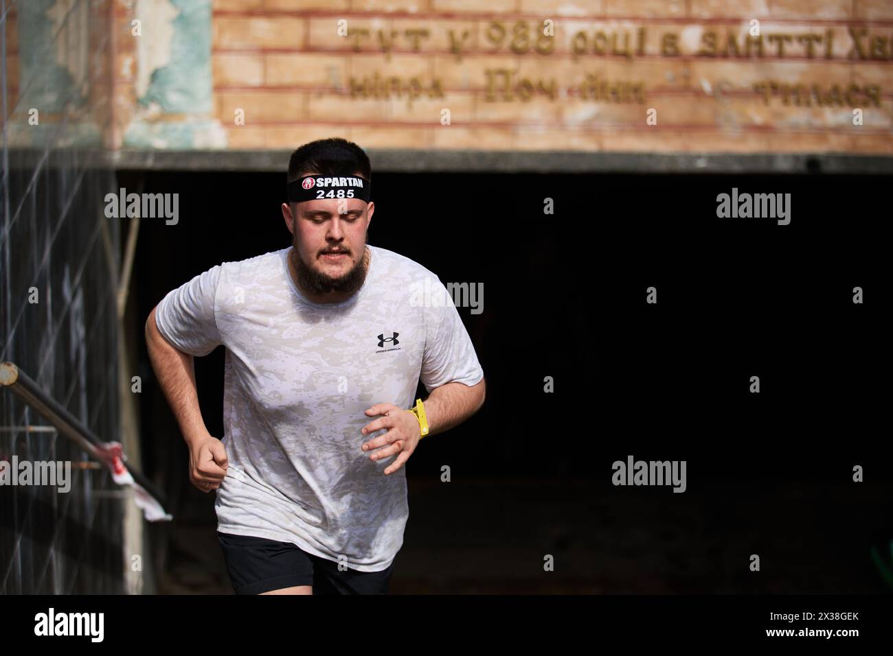Chubby guy running a marathon at the Spartan Race competition in Kyiv ...