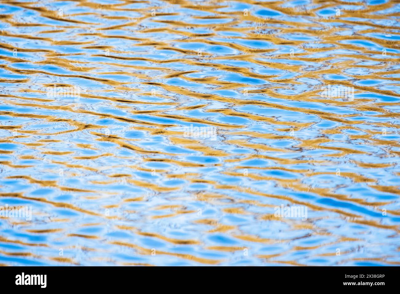 Water surface with abstract colorful pattern of ripple reflections ...