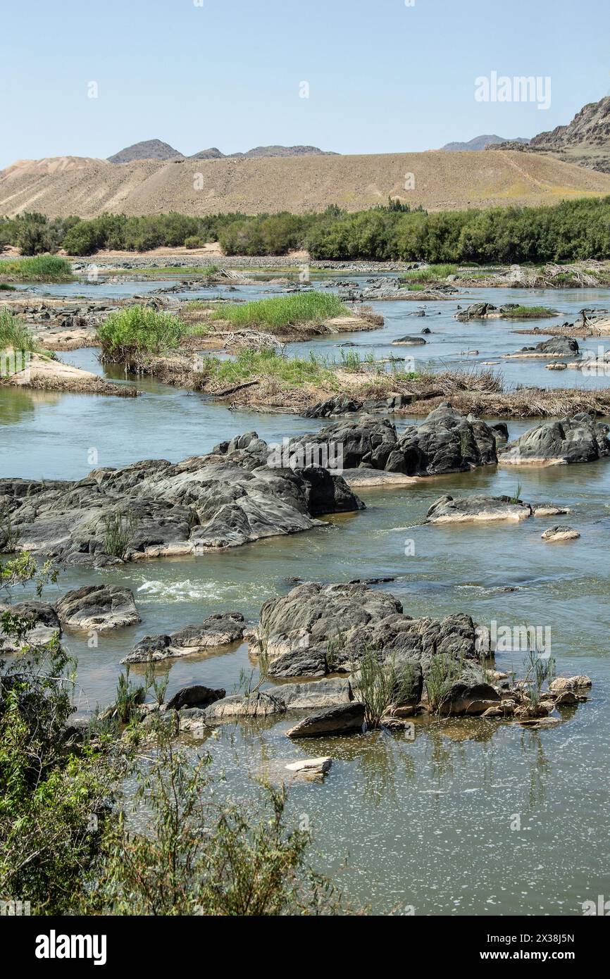 Rocks and islands in the blue water of the Orange River with a waste ...