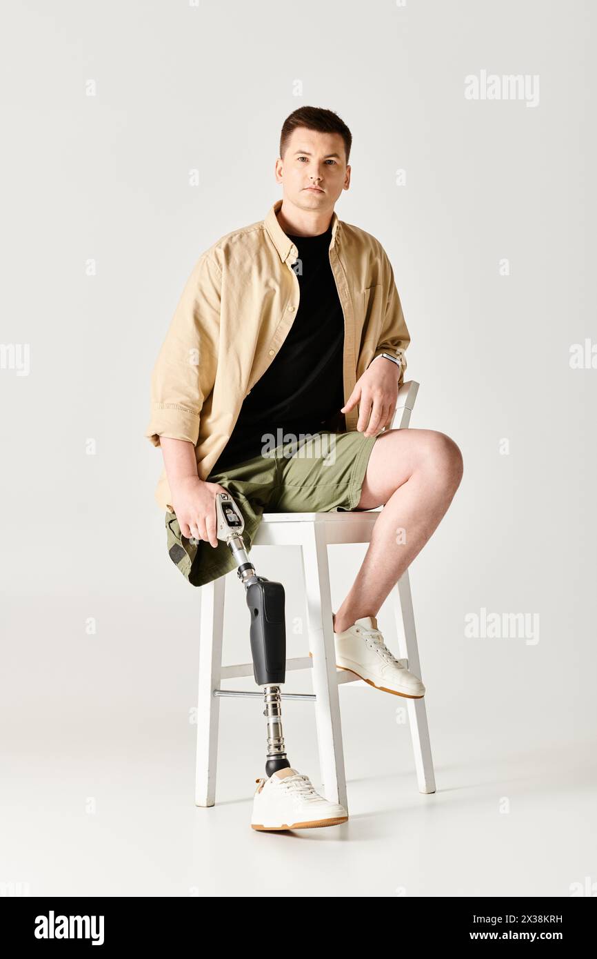 Handsome man with prosthetic leg actively poses on top of white stool ...