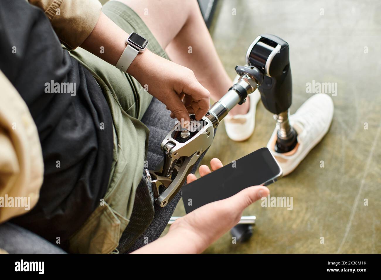 A businessman with a prosthetic leg siting and checking his cell phone ...