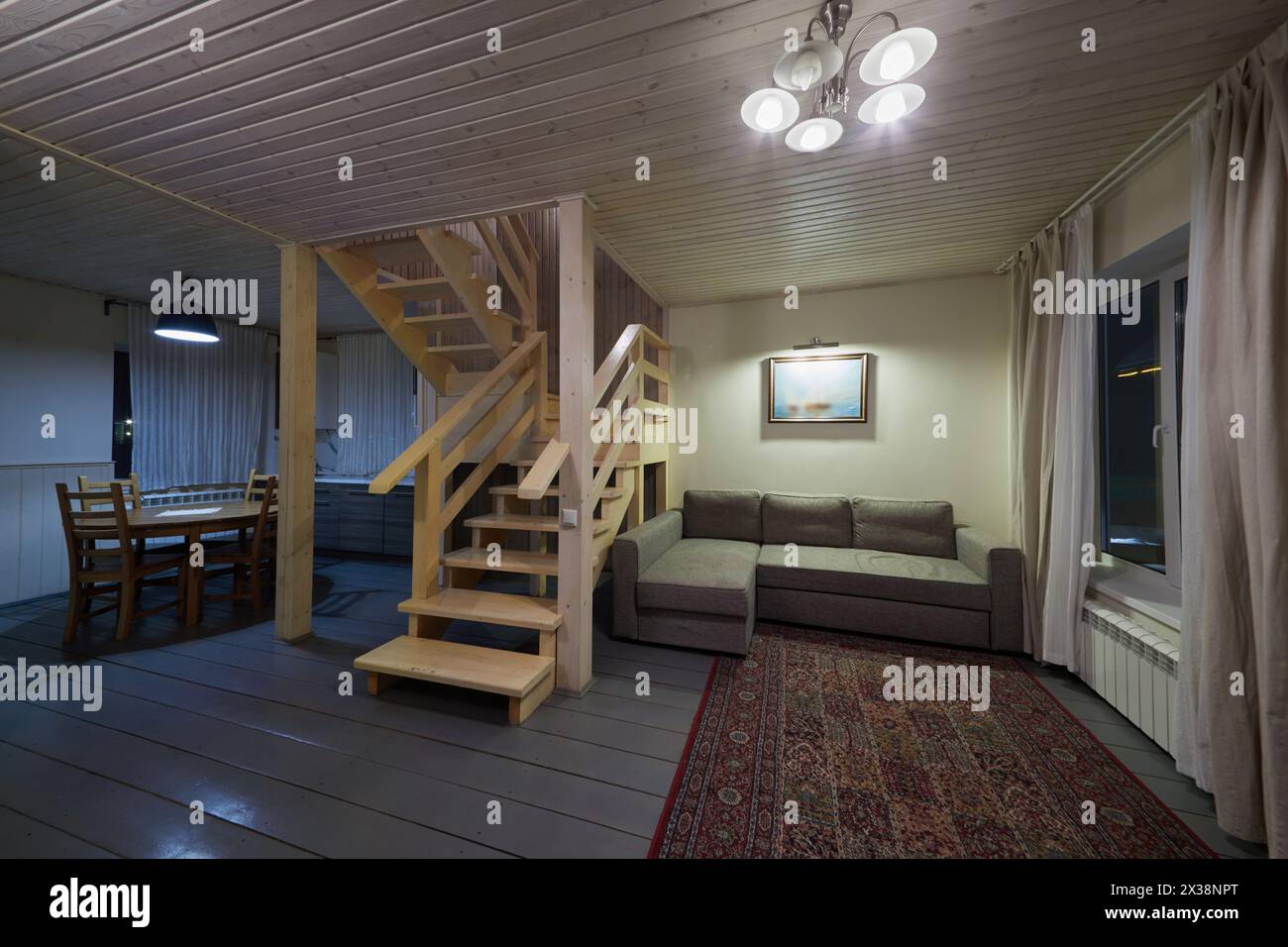 Interior of first floor of wooden house with rest area, kitchen, stairs ...