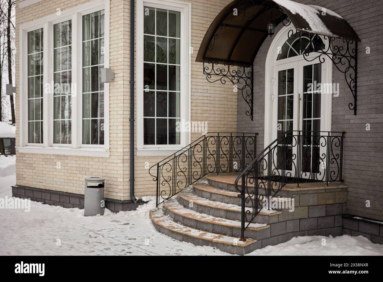 House of bricks, stone steps of porch with metal handrails and entrance ...