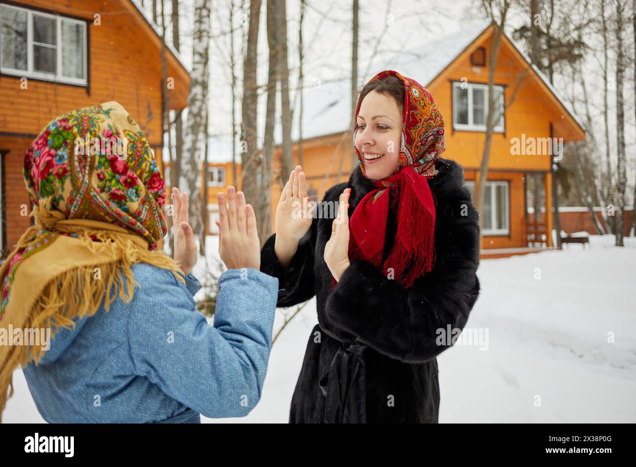 Smiling woman and teenage girl in folk style shawls stand against ...