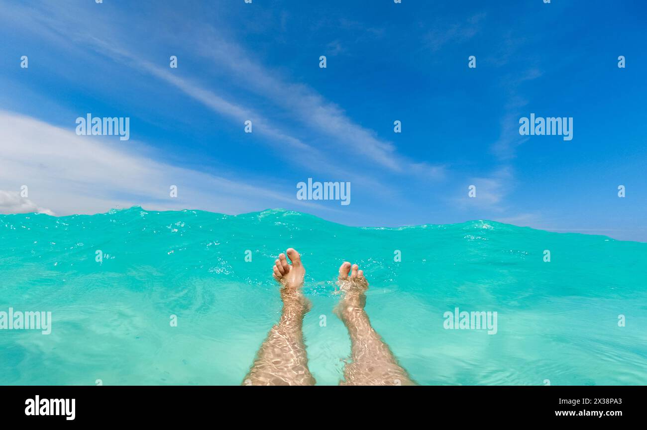 Woman feet swim underwater beneath the surface. View of female's feet ...