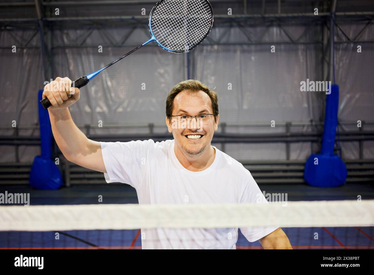 Smiling man in glasses with badminton racket at sports ground Stock ...