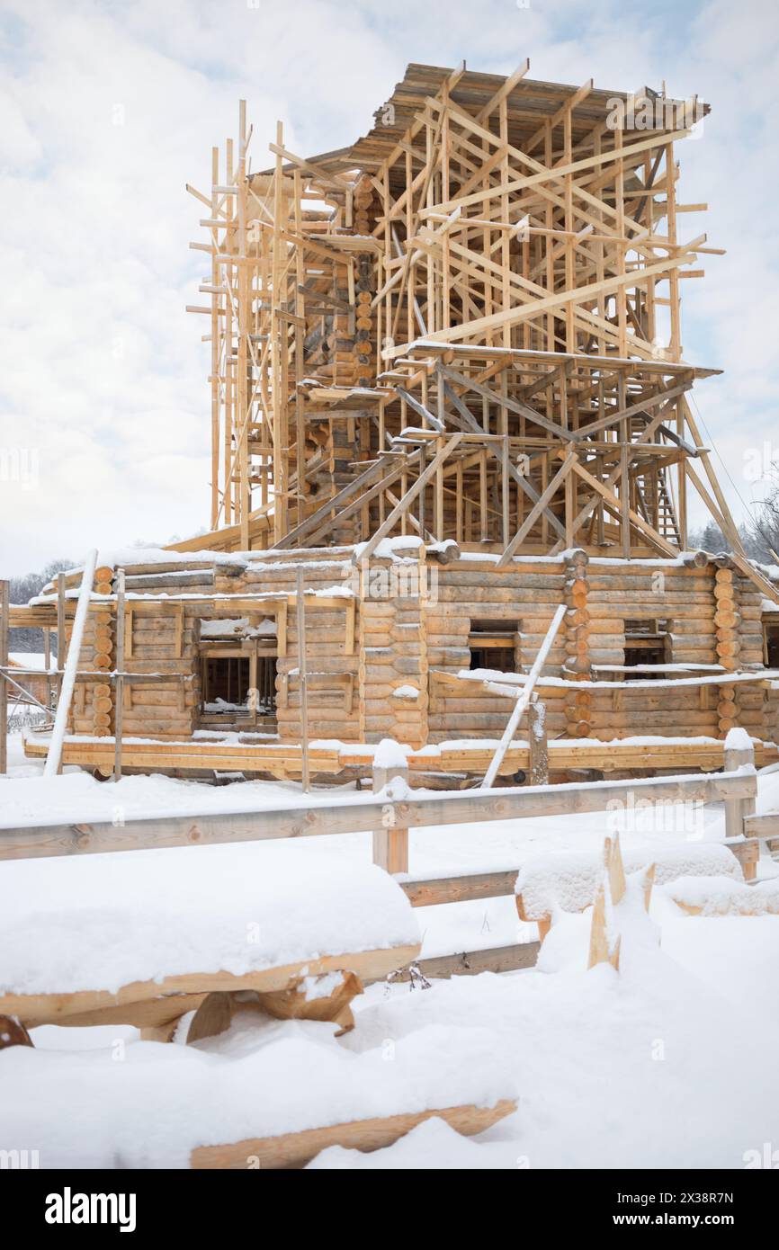 Wooden old-style building under construction and scaffolding in Russian ...