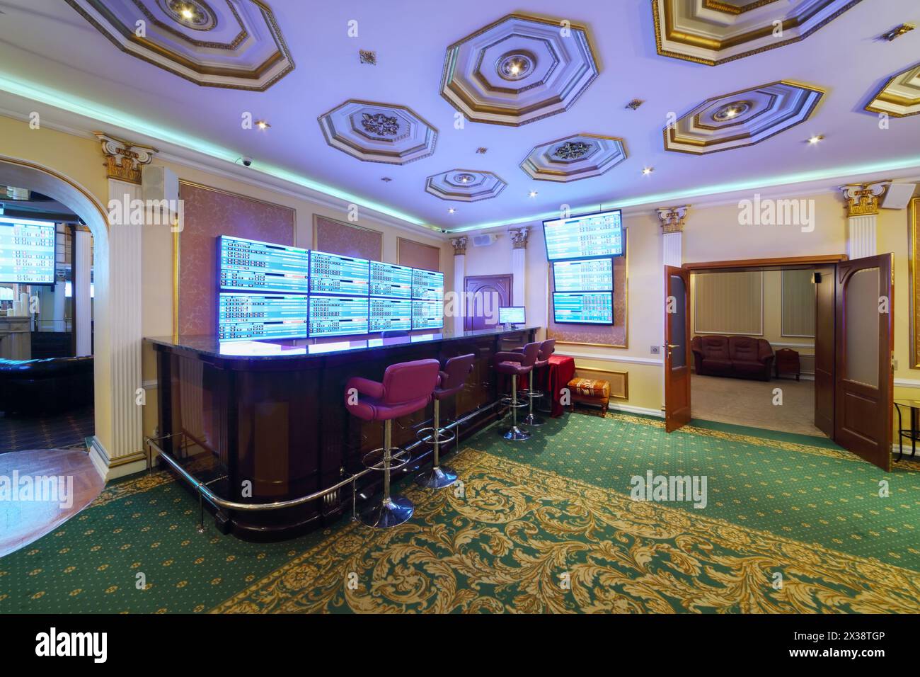 Empty wooden counter and lot of screens in luxury bookmaker office ...