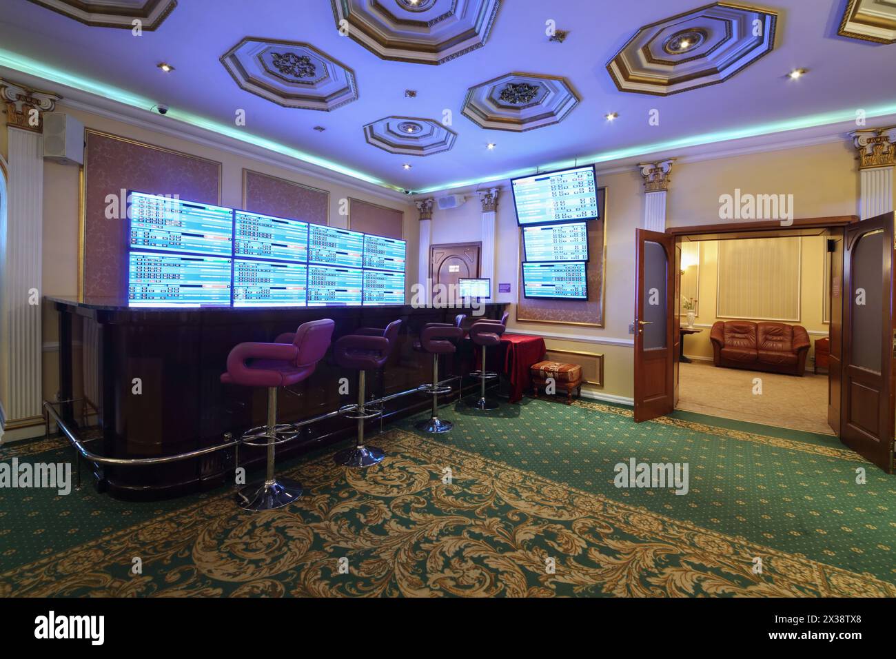 Empty wooden counter and lot of screens in luxury bookmaker office with ...