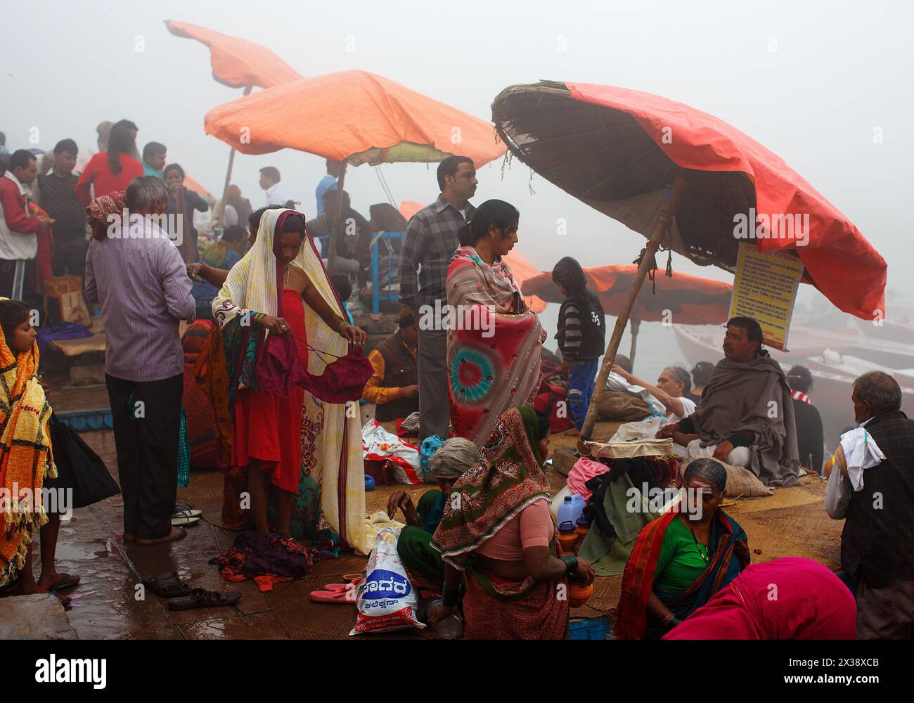 Pilgrim activity on a foggy morning on the banks of the Ganges River at ...