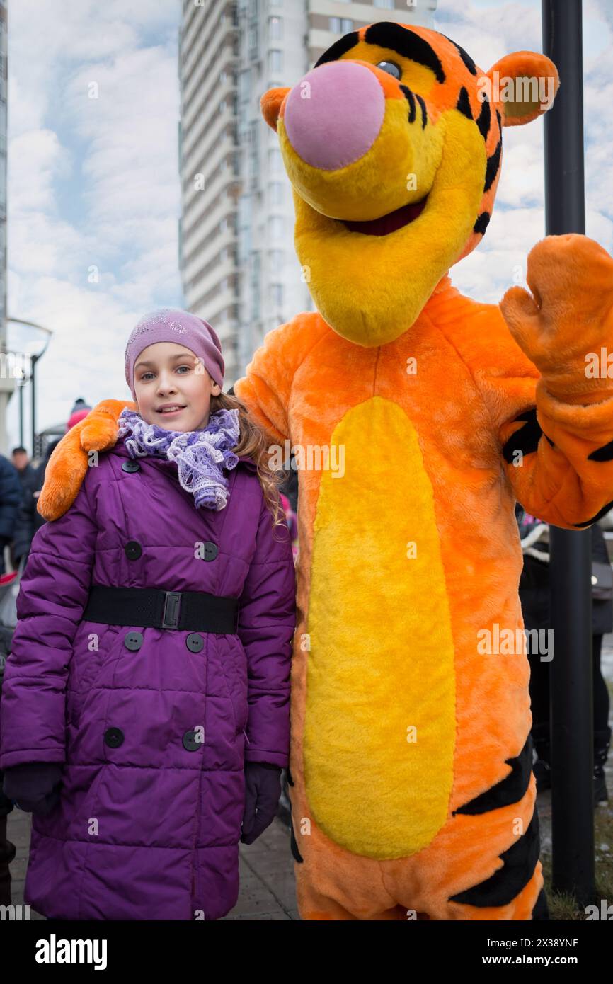 Little girl in purple jacket with tiger life-size puppet Stock Photo ...