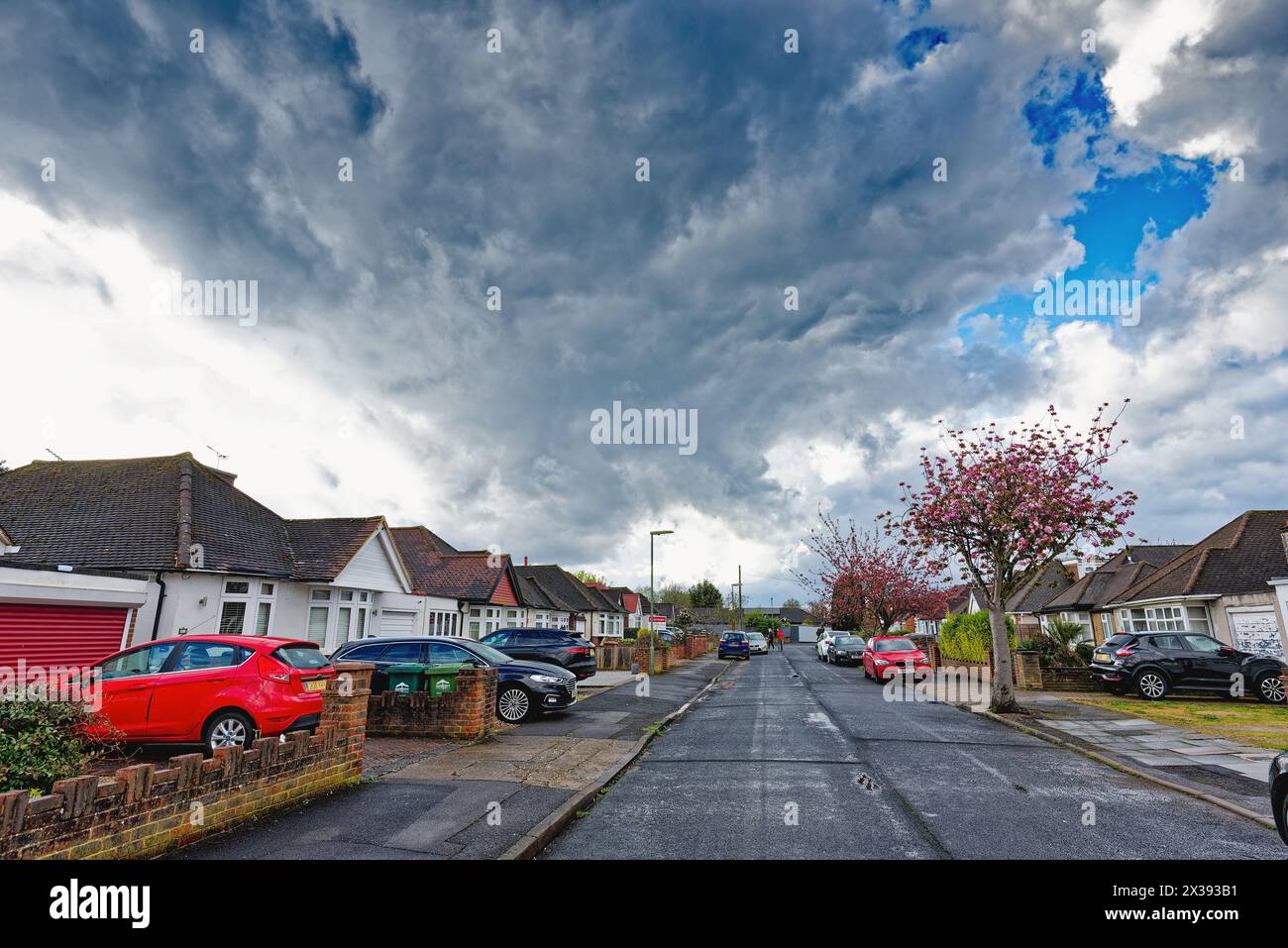 Dramatic storm clouds forming over a suburban residential road in ...