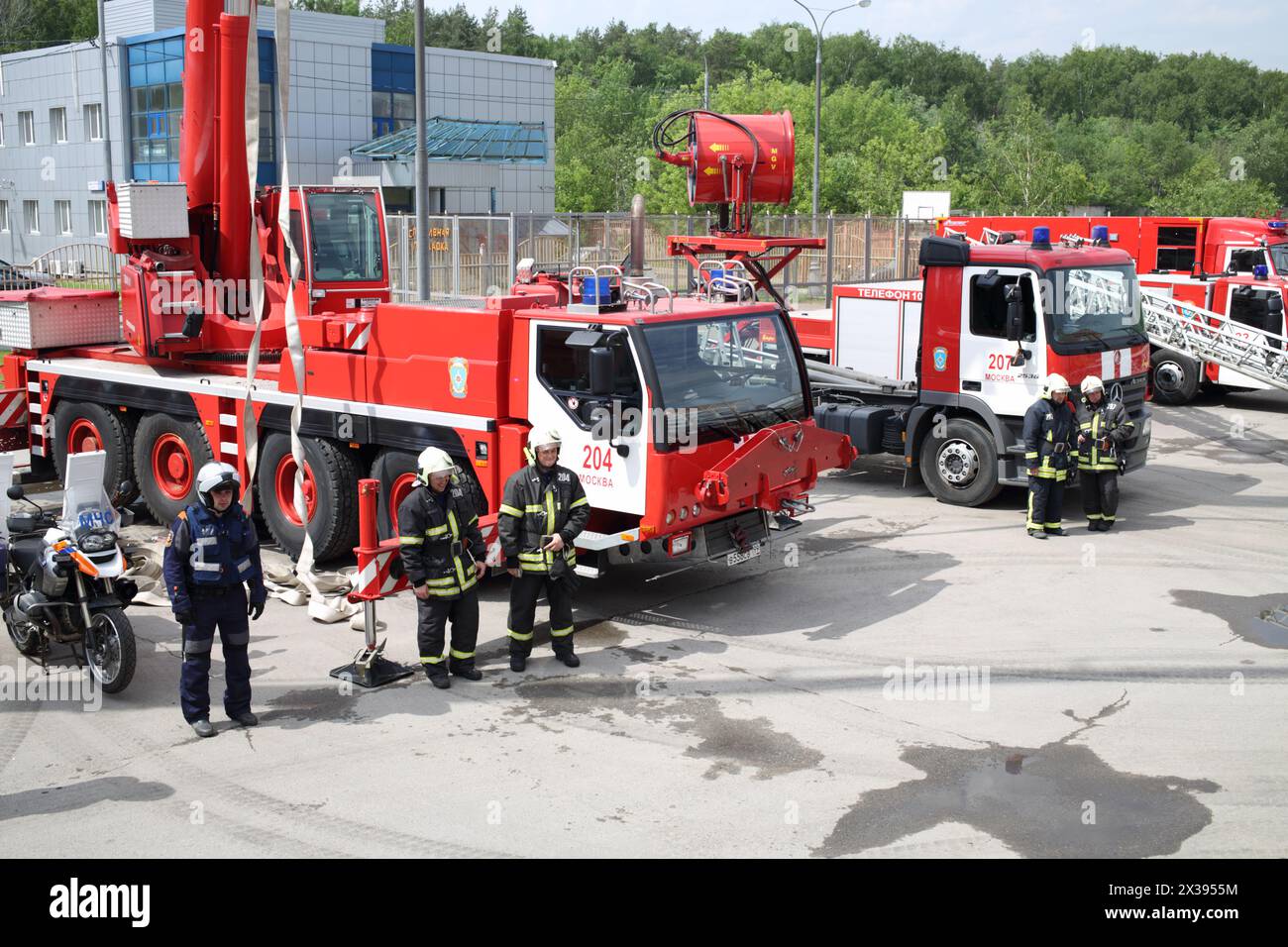 Fire trucks, fire engine with crane and motorcycles stand on territory ...