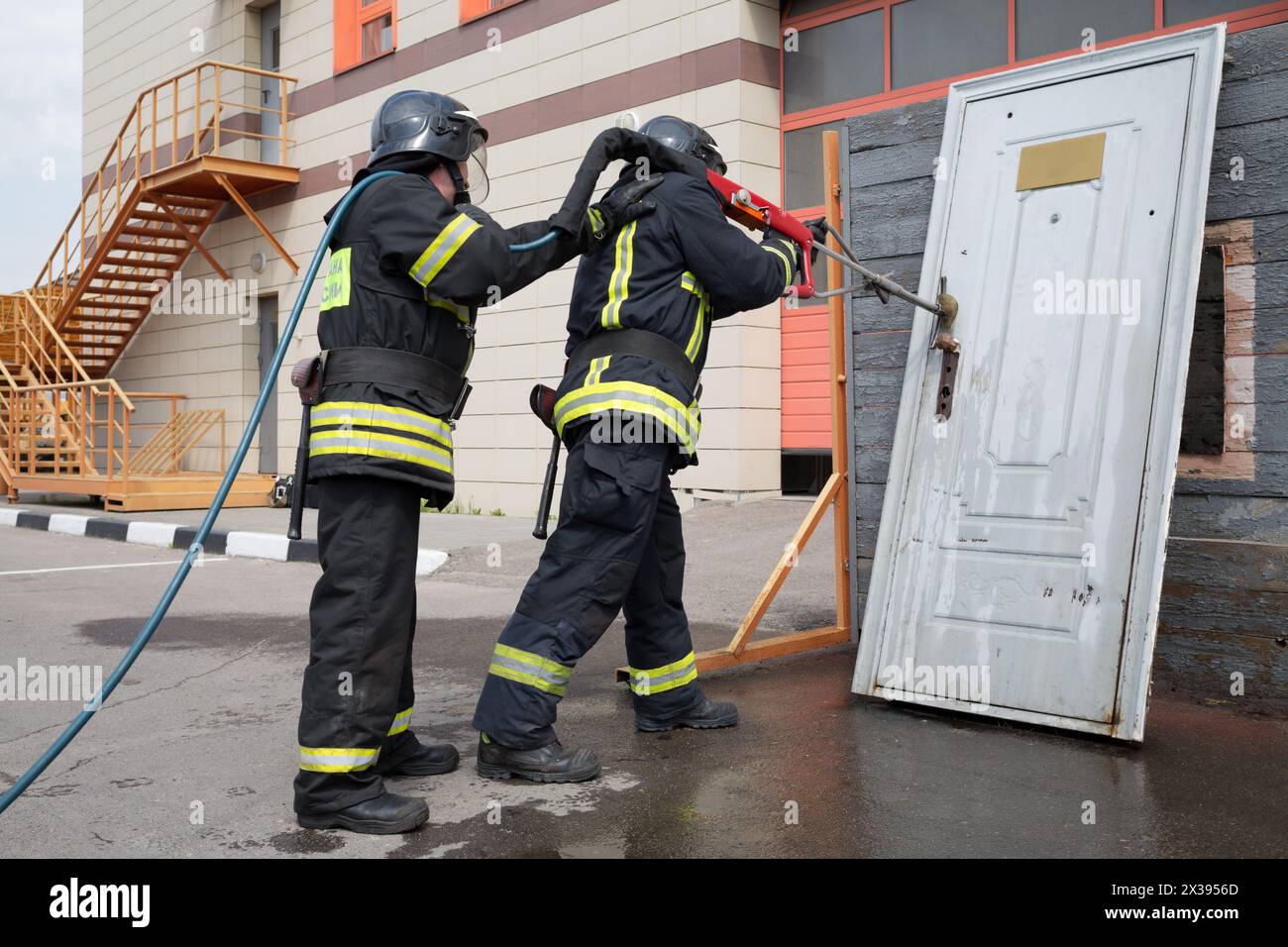 Two firefighters demonstrate lock snapping with wooden door Stock Photo ...