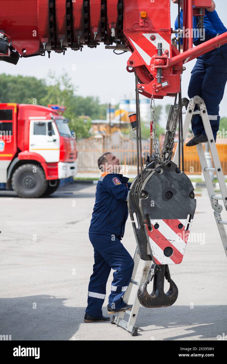 Two firefighters near the truck with fire crane Stock Photo - Alamy