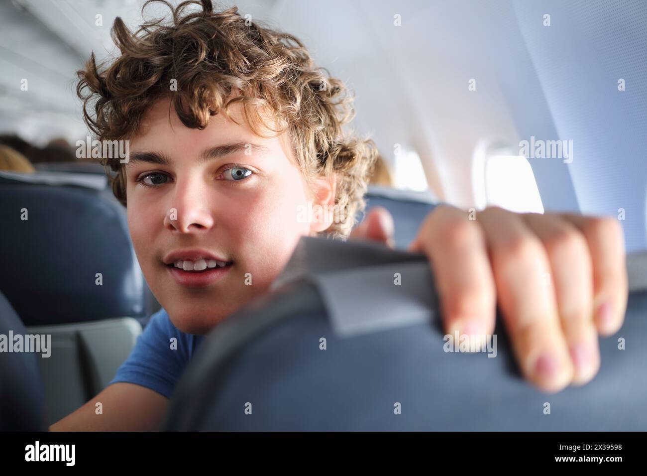 Handsome teenager boy looks into camera in airplane during trip Stock ...