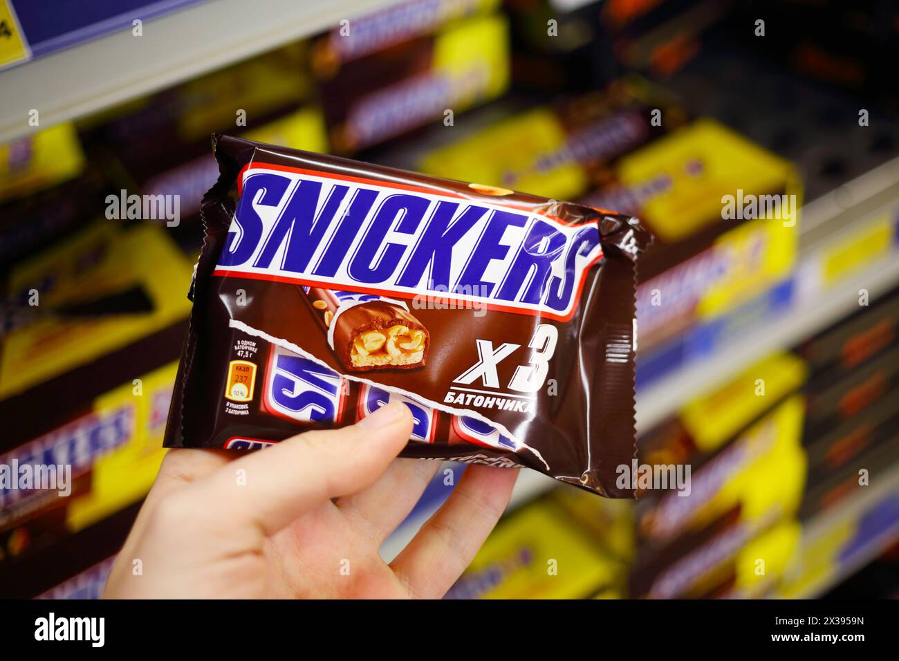 MOSCOW, RUSSIA - APR 27, 2016: Man is holding package of Snickers in ...