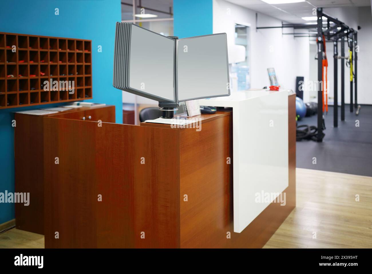Stylish reception with wooden counter and blue walls in fitness center ...
