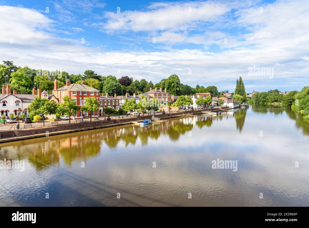 Residential buildings along a riverside street lined with benches ...